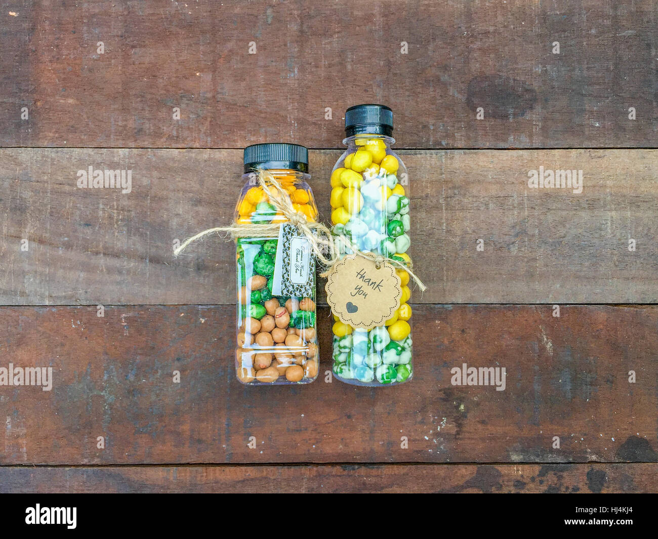 Variety of nuts and peanuts in the plastic bottle on the wooden table ...