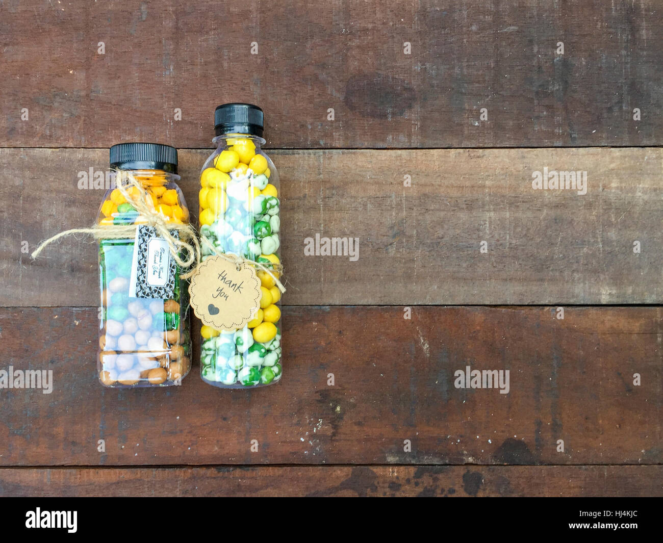 Variety of nuts and peanuts in the plastic bottle on the wooden table ...