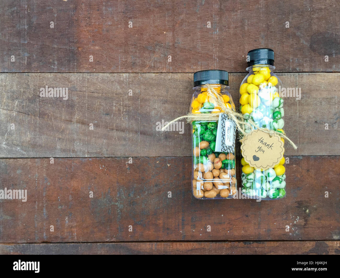 Variety of nuts and peanuts in the plastic bottle on the wooden table ...