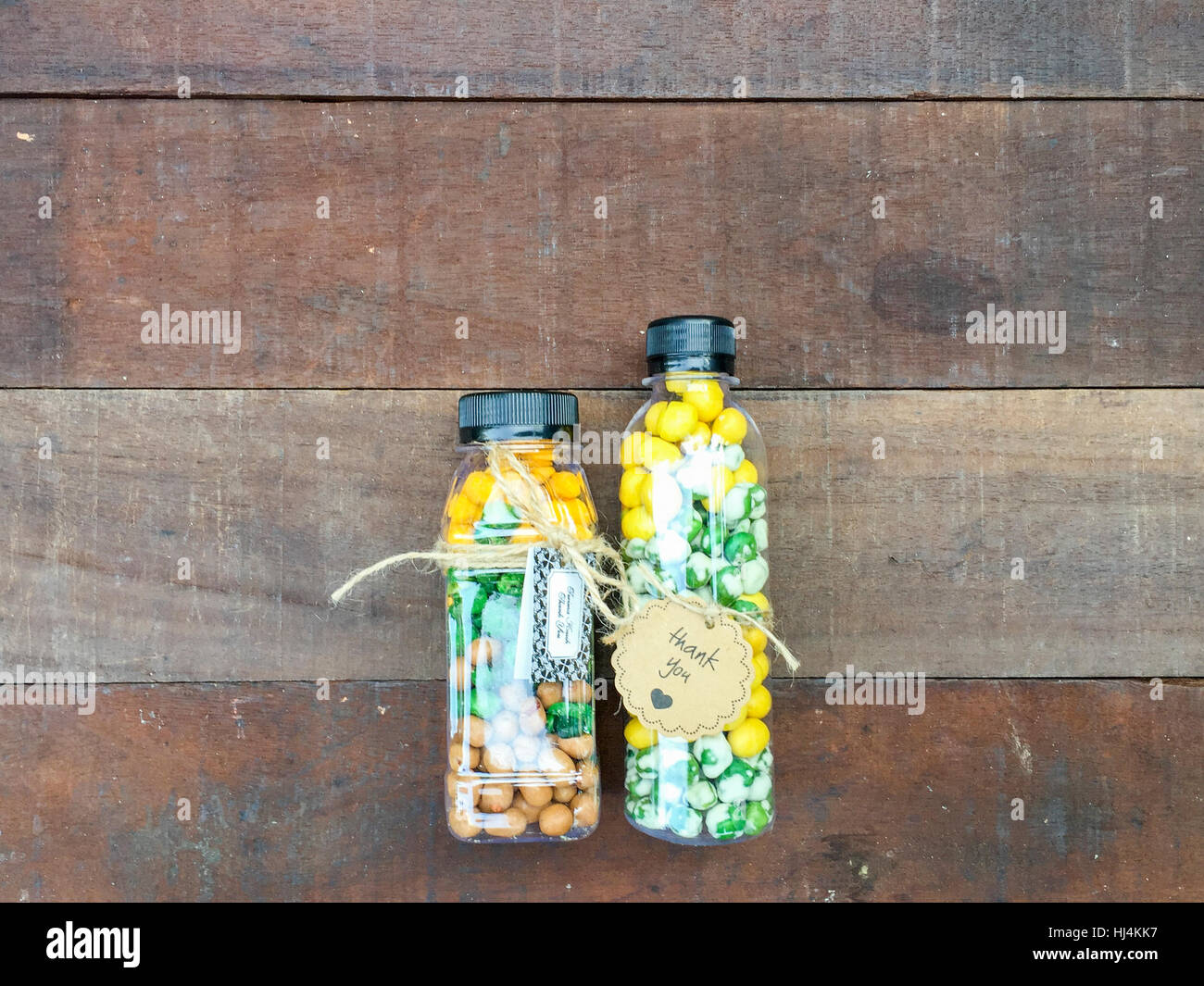 Variety of nuts and peanuts in the plastic bottle on the wooden table ...