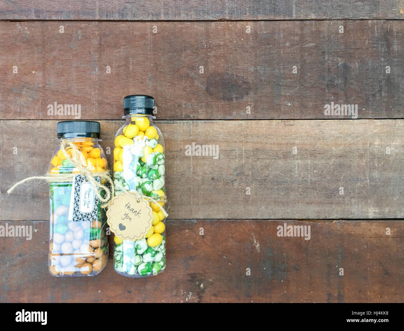 Variety of nuts and peanuts in the plastic bottle on the wooden table ...