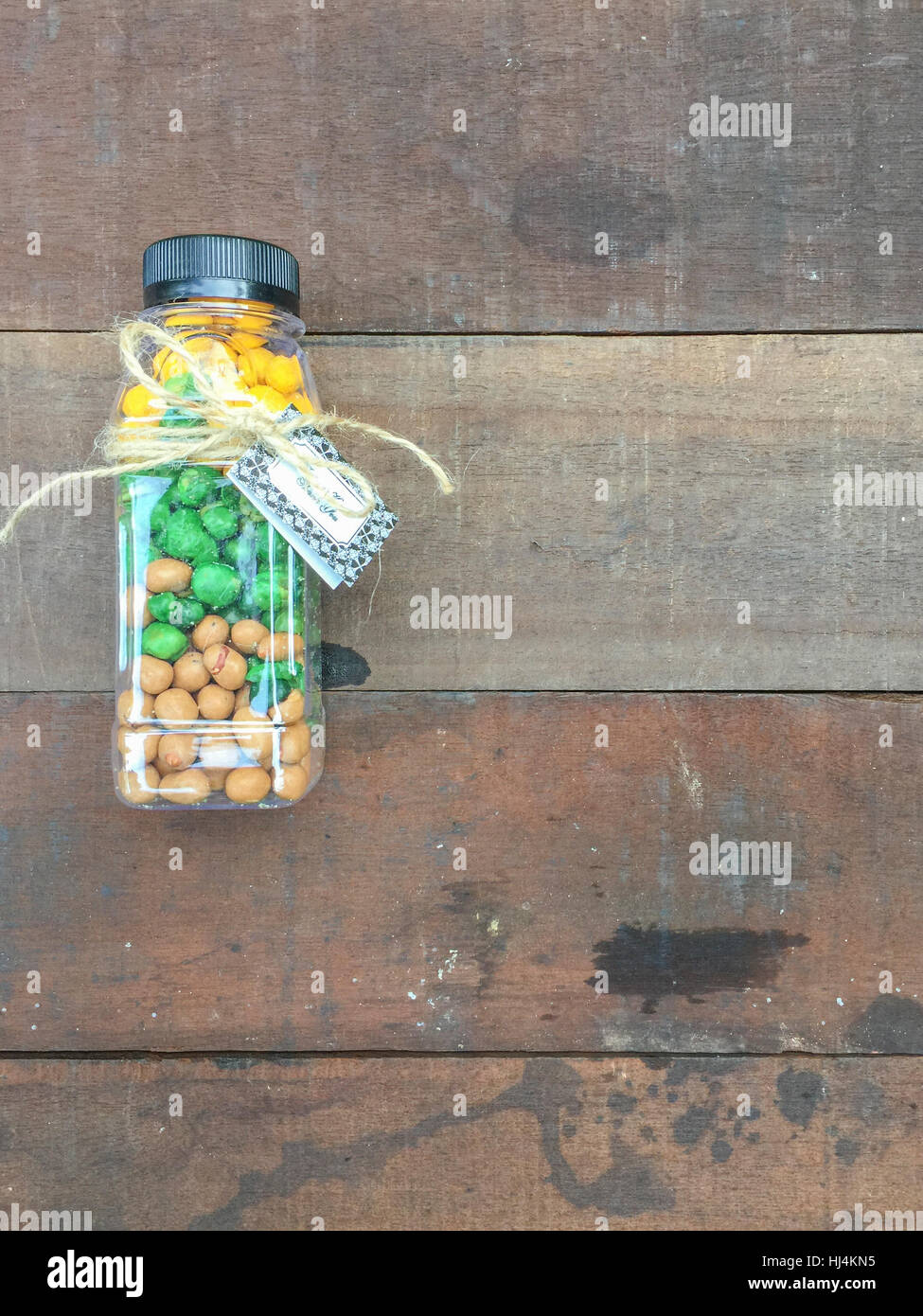 Variety of nuts and peanuts in the plastic bottle on the wooden table ...