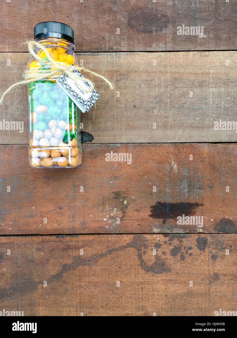 Variety of nuts and peanuts in the plastic bottle on the wooden table ...