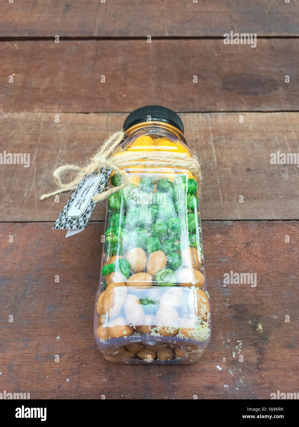 Variety of nuts and peanuts in the plastic bottle on the wooden table ...