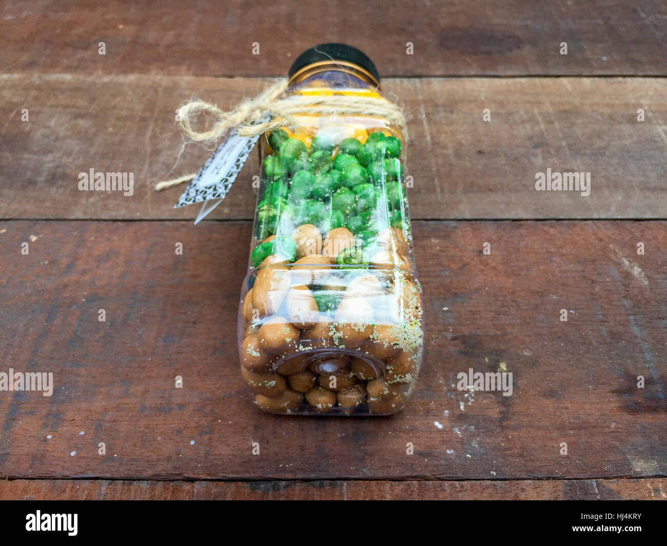 Variety of nuts and peanuts in the plastic bottle on the wooden table ...