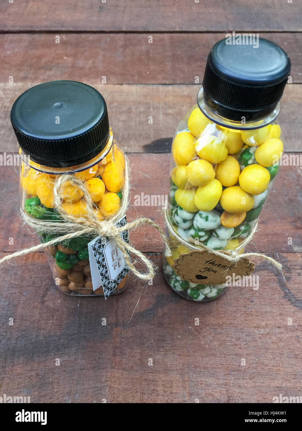 Variety of nuts and peanuts in the plastic bottle on the wooden table ...