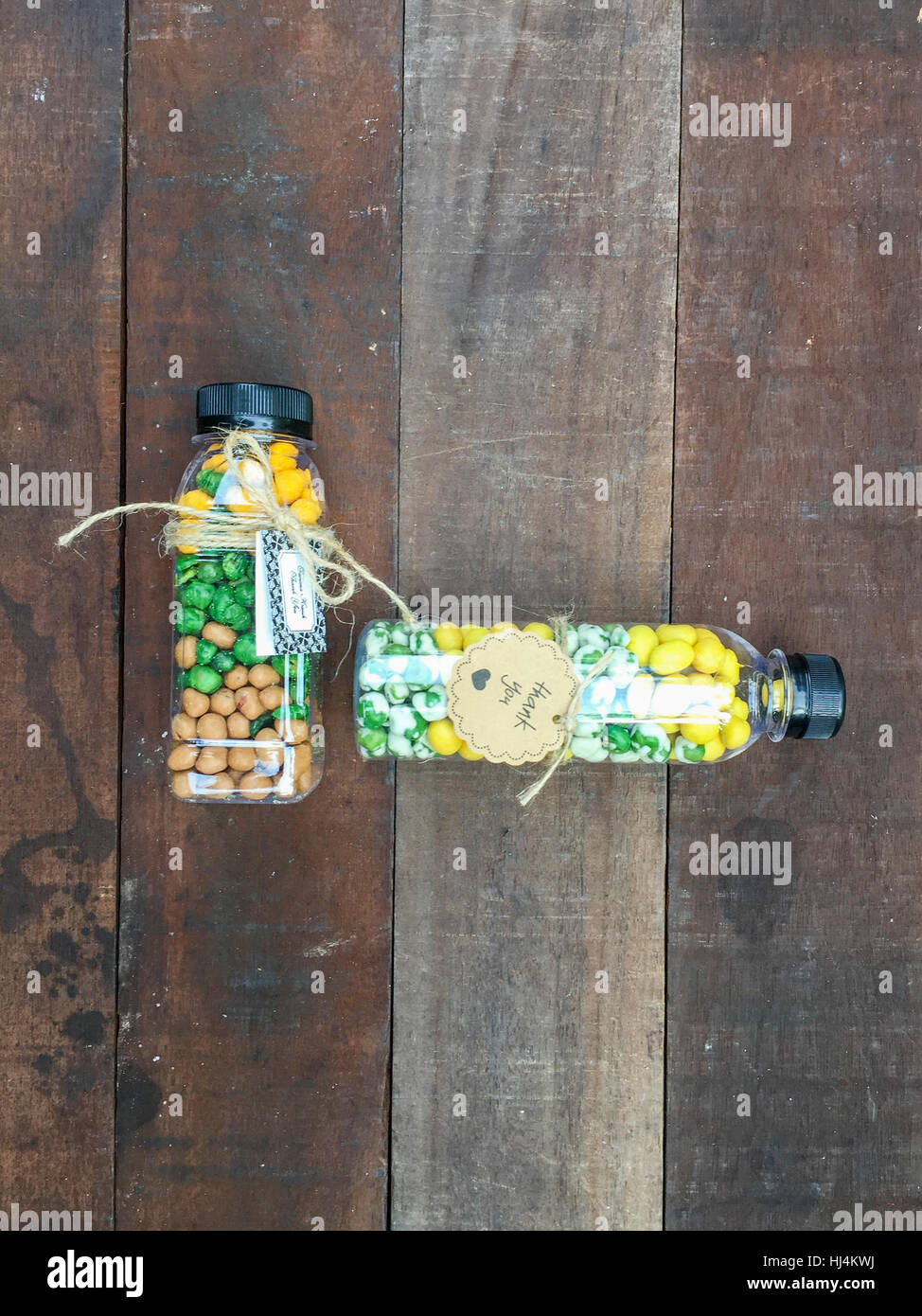 Variety of nuts and peanuts in the plastic bottle on the wooden table ...