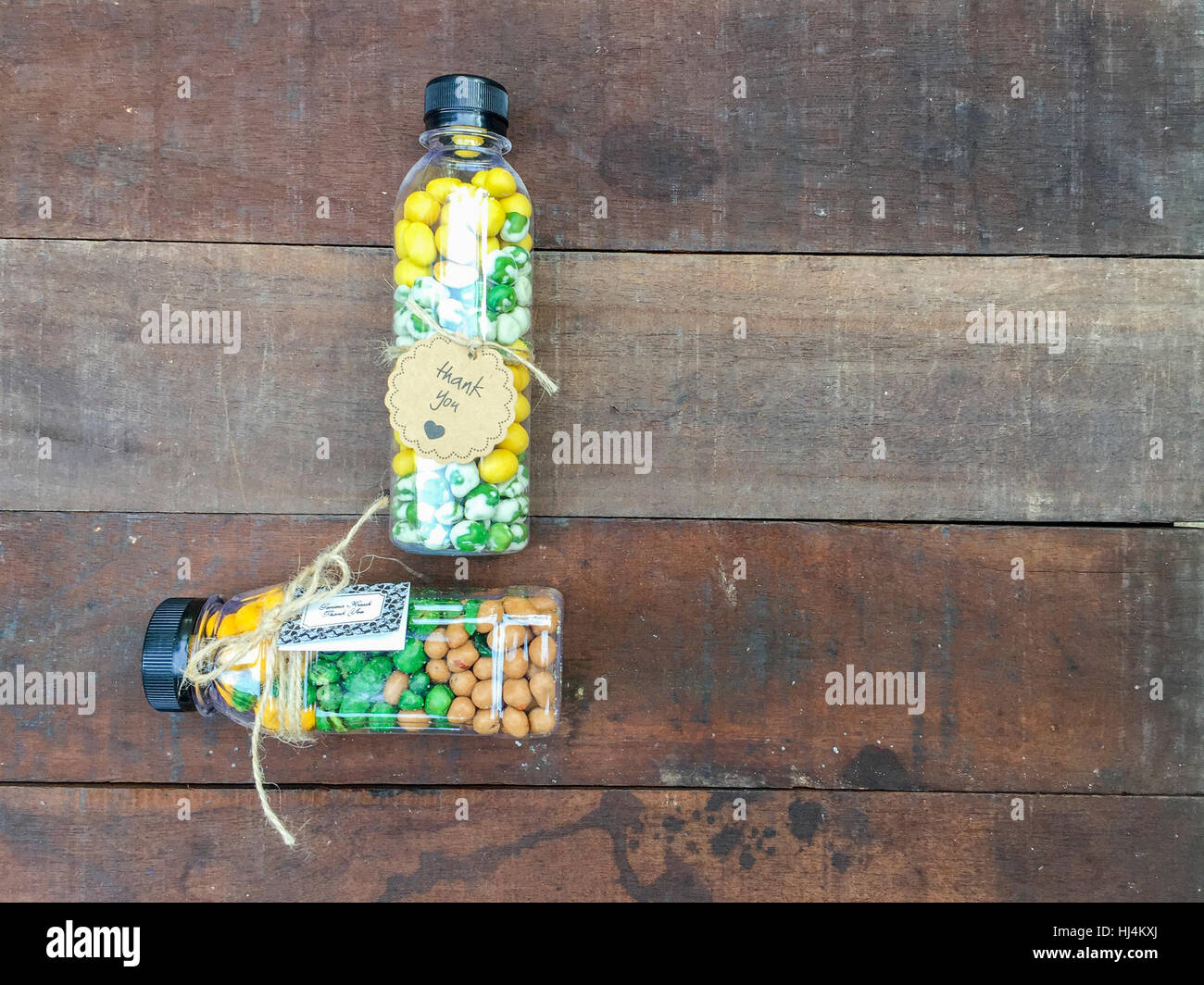 Variety of nuts and peanuts in the plastic bottle on the wooden table ...