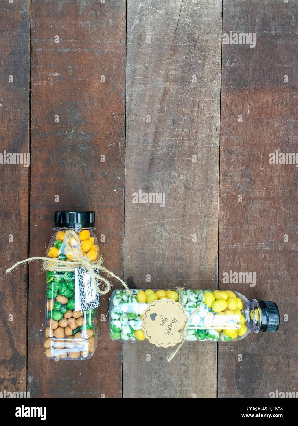 Variety of nuts and peanuts in the plastic bottle on the wooden table ...