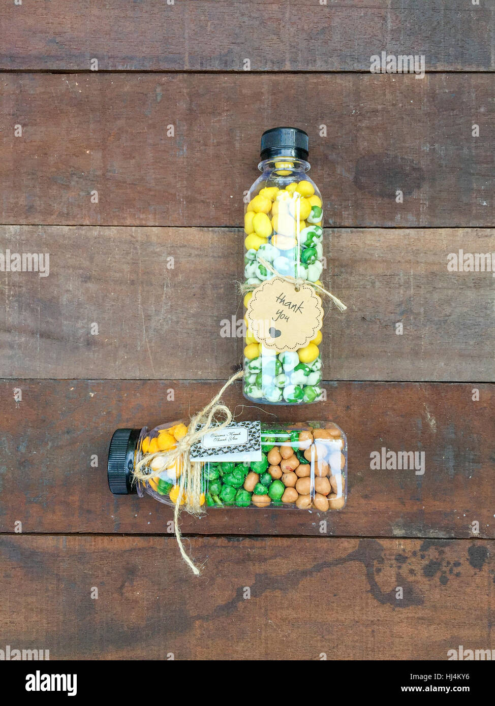 Variety of nuts and peanuts in the plastic bottle on the wooden table ...