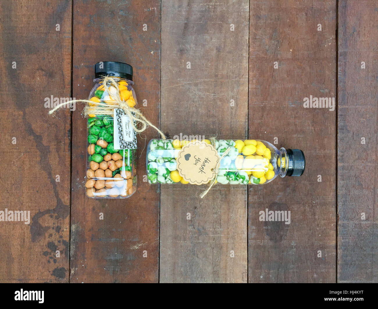 Variety of nuts and peanuts in the plastic bottle on the wooden table ...