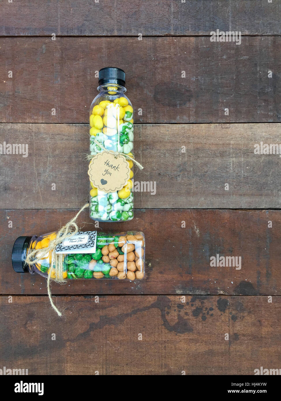 Variety of nuts and peanuts in the plastic bottle on the wooden table ...