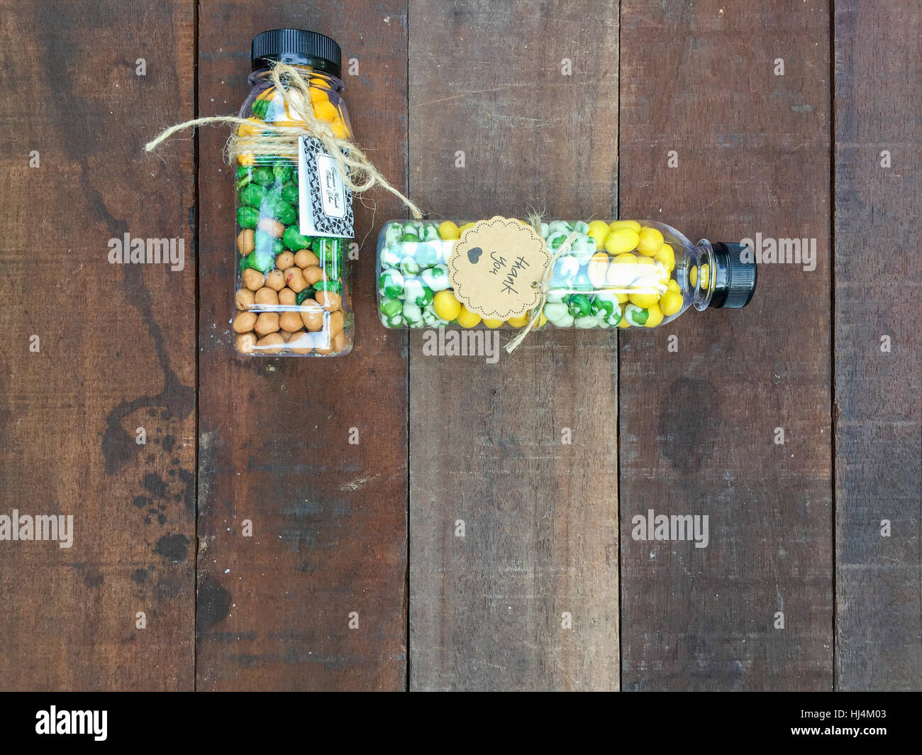 Variety of nuts and peanuts in the plastic bottle on the wooden table ...