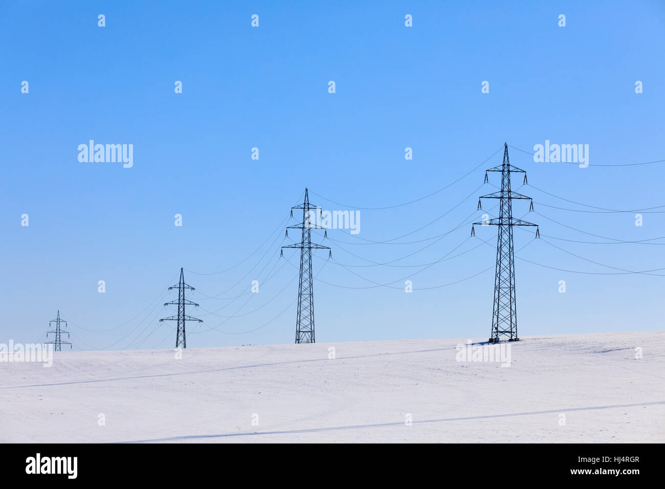 high voltage power lines in winter landscape against a blue sky Stock ...