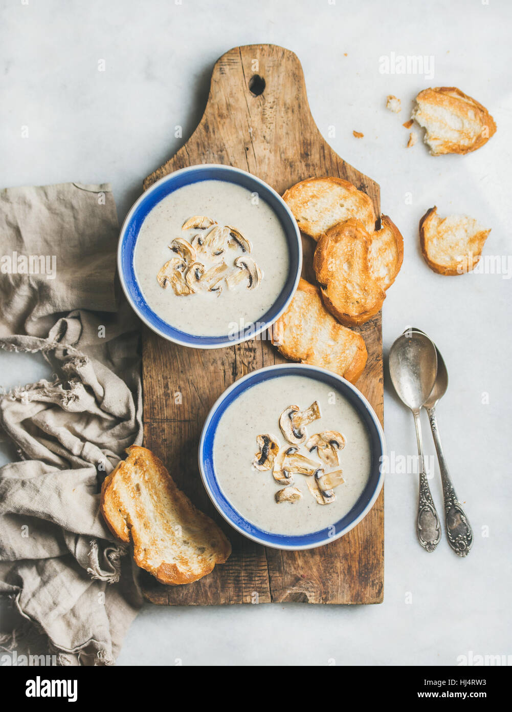 Creamy mushroom soup in bowls with toasted bread, marble background ...