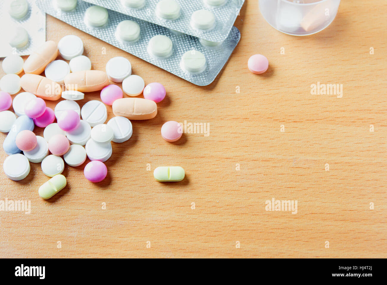 Assortment of pills, tablets and capsules on wooden table with copy ...