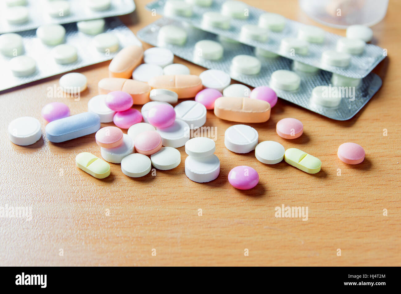 Assortment of pills, tablets and capsules on wooden table with copy ...