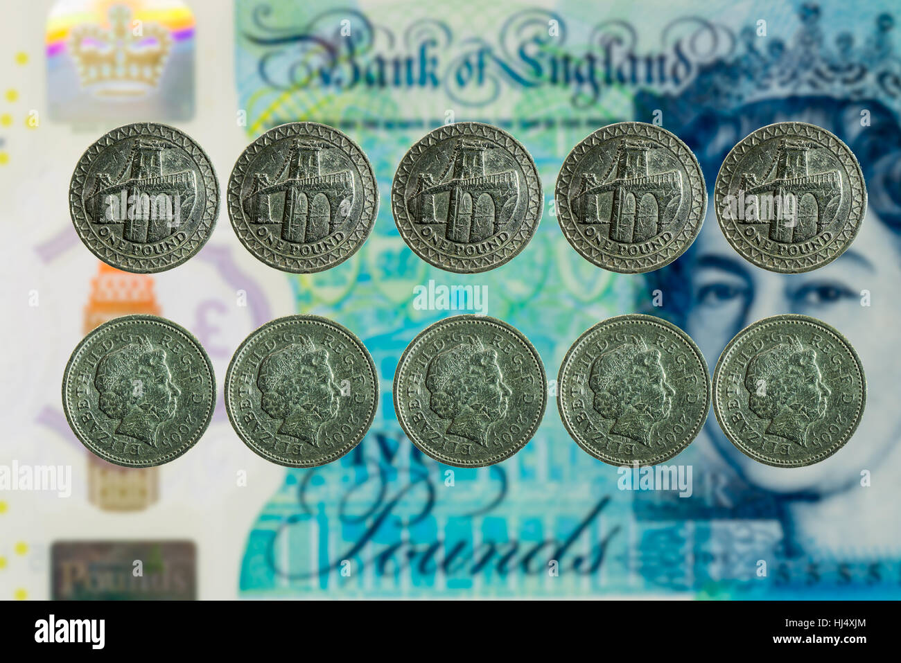 British pound coins showing both sides and out of focus five pound note ...