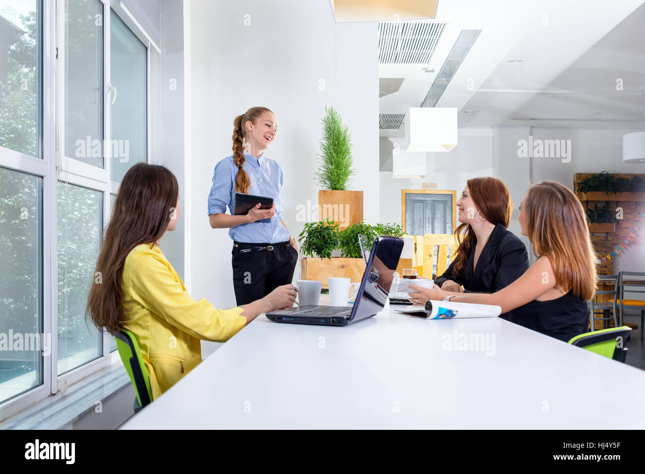 Pretty young business woman giving a presentation in conference or ...