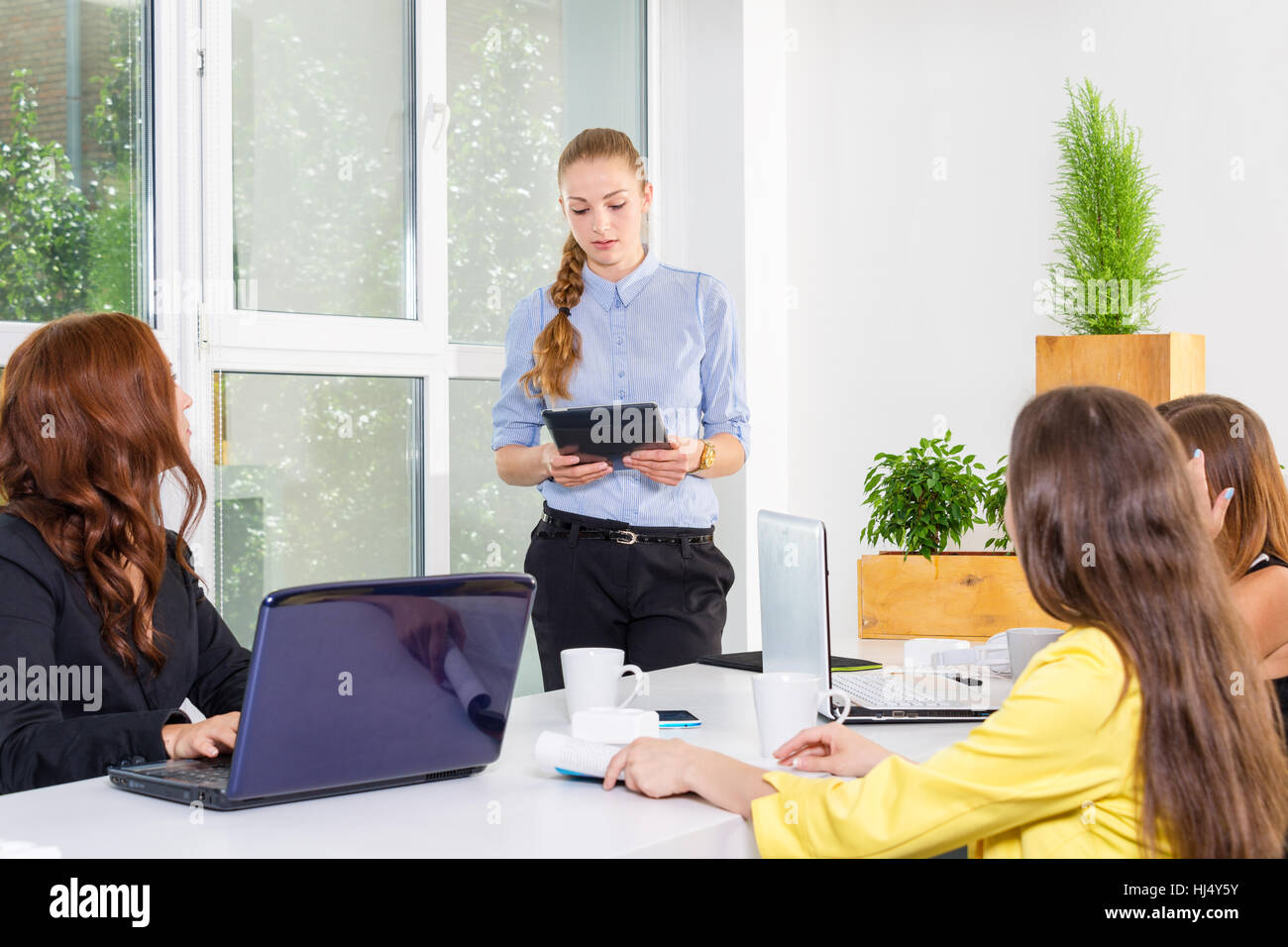 Pretty young business woman giving a presentation in conference or ...