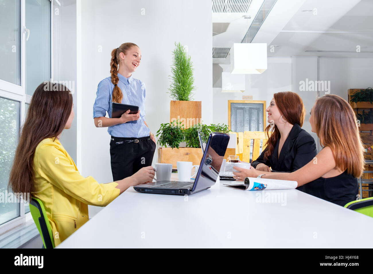 Pretty young business woman giving a presentation in conference or ...