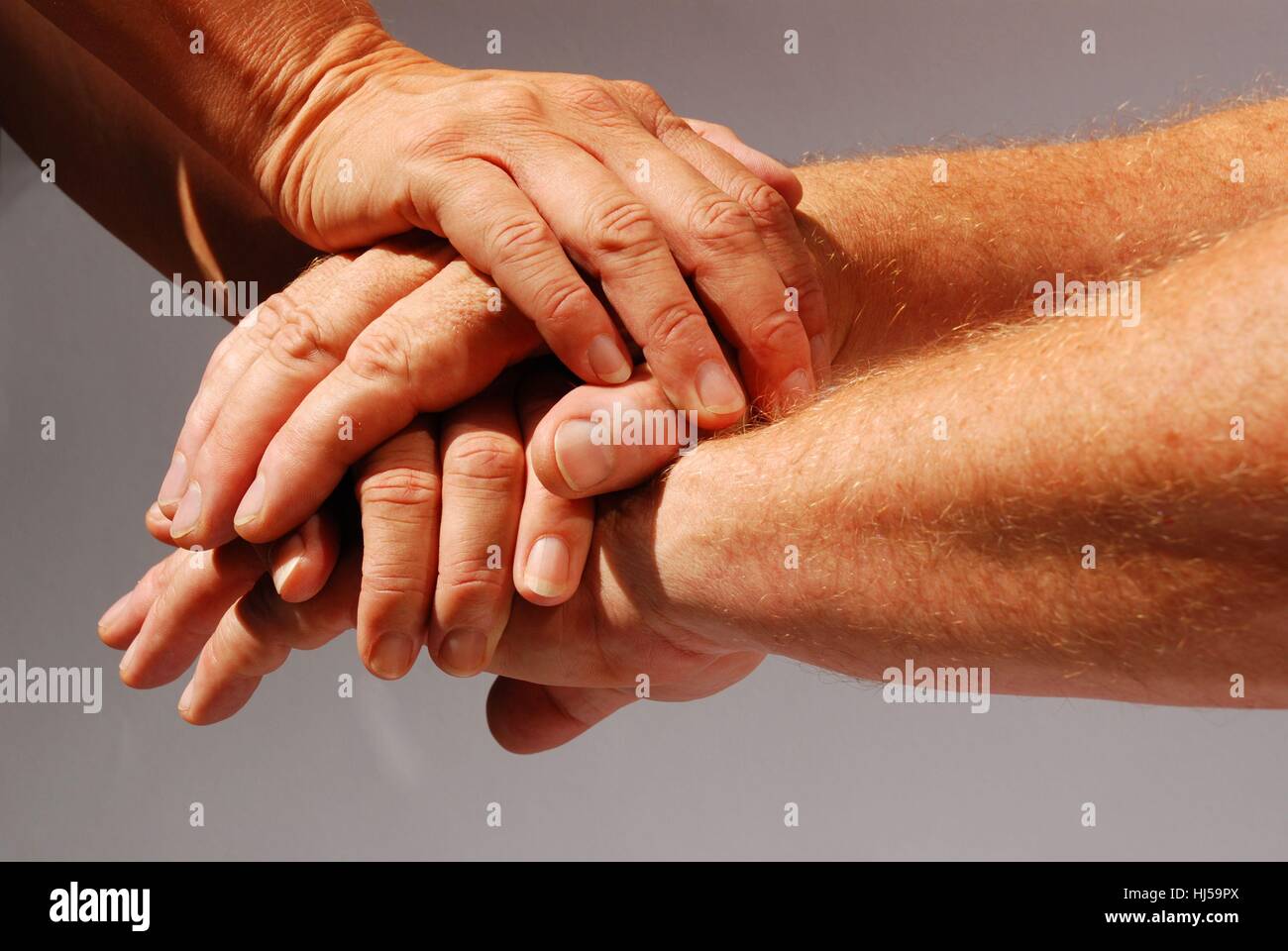 four hands symbolizing community, trust and power Stock Photo - Alamy