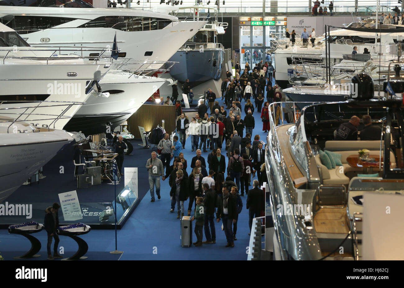 Visitors walk between yachts on display at the international boat ...