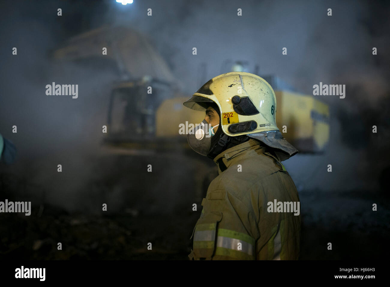 Tehran, Iran. 25th Jan, 2017. A firefighter searches for victims at the ...