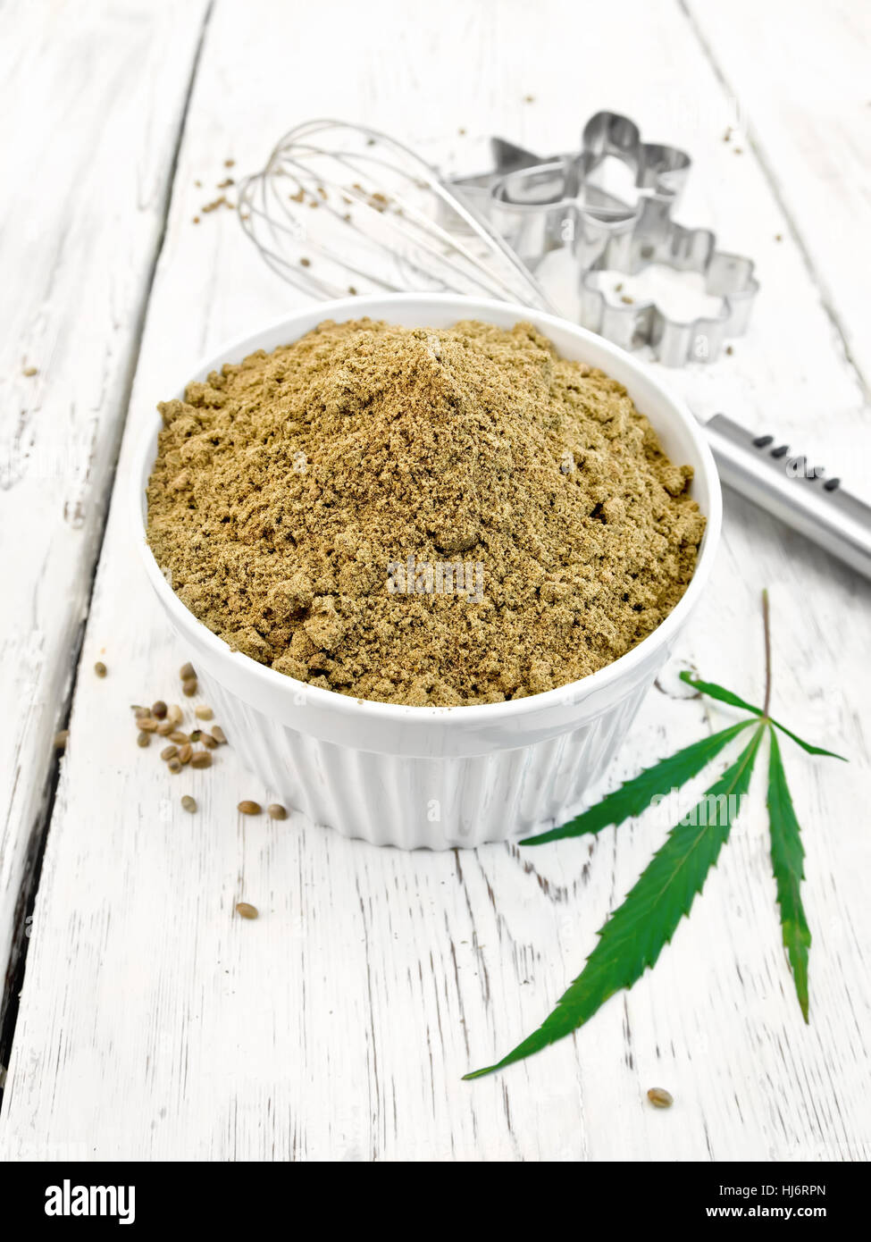 Hemp flour in a bowl, mixer and cookie cutters, cannabis leaves on the ...