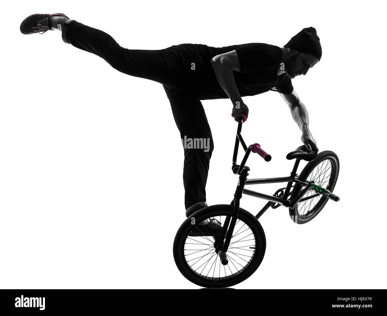 one caucasian man exercising bmx acrobatic figure in silhouette studio ...