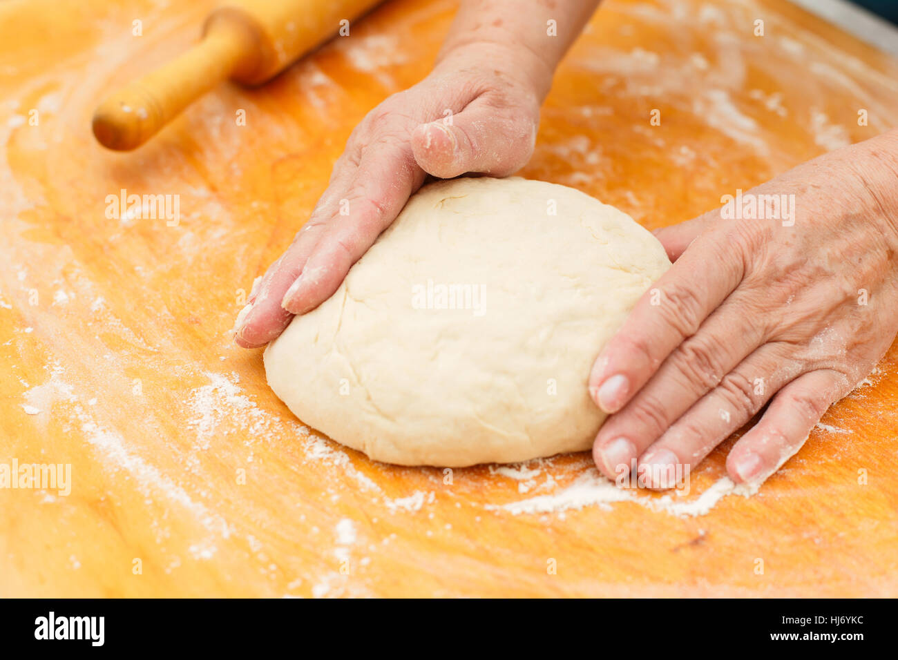 Woman cooks dough on table Stock Photo - Alamy