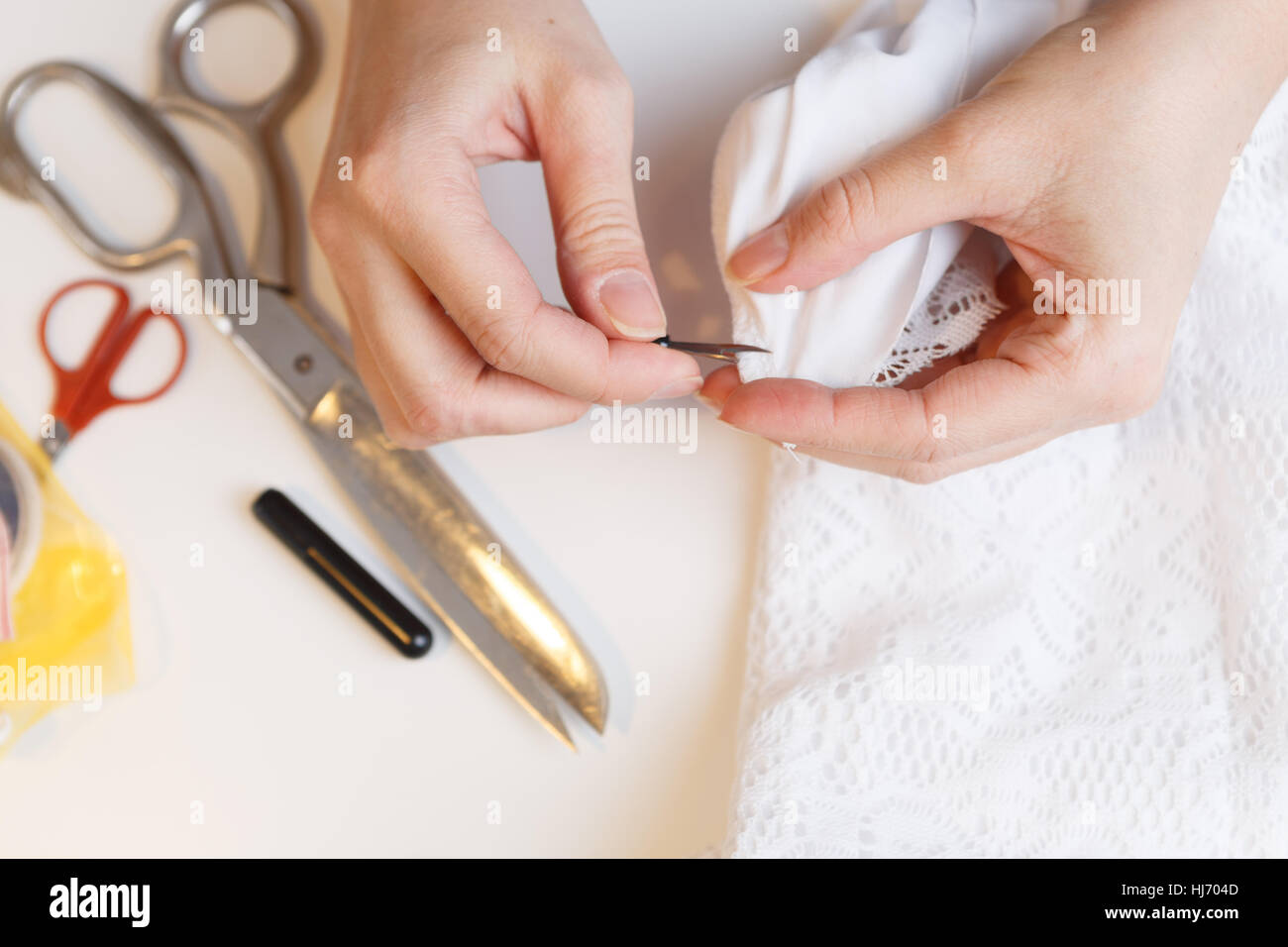 Woman unpick fabric on table Stock Photo - Alamy