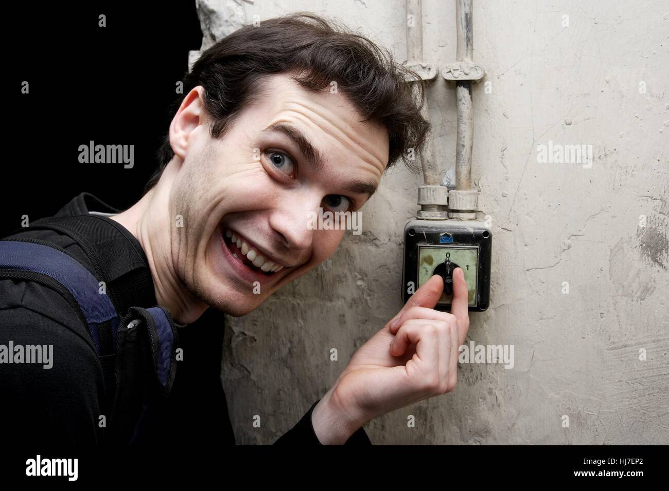 Man with crazy expression about to turn on a switch Stock Photo - Alamy