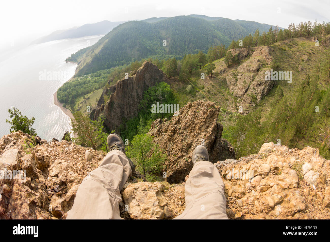 Feet hanging over the cliff rock top view. Baikal Stock Photo - Alamy
