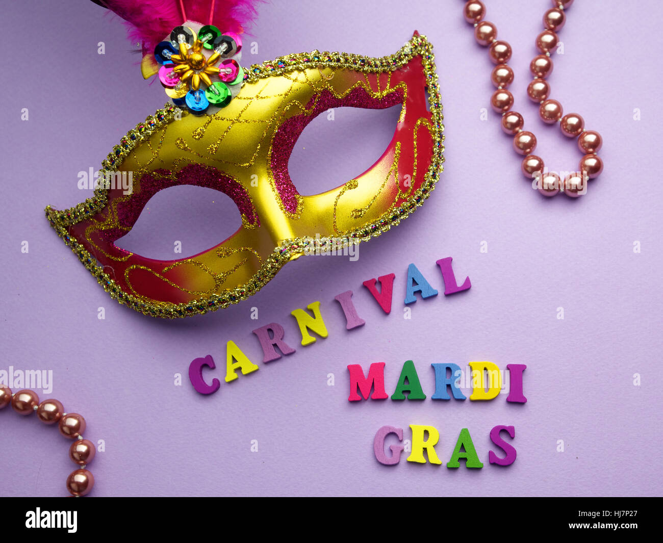 Colorful mardi gras or carnivale mask on a purple background. Venetian ...