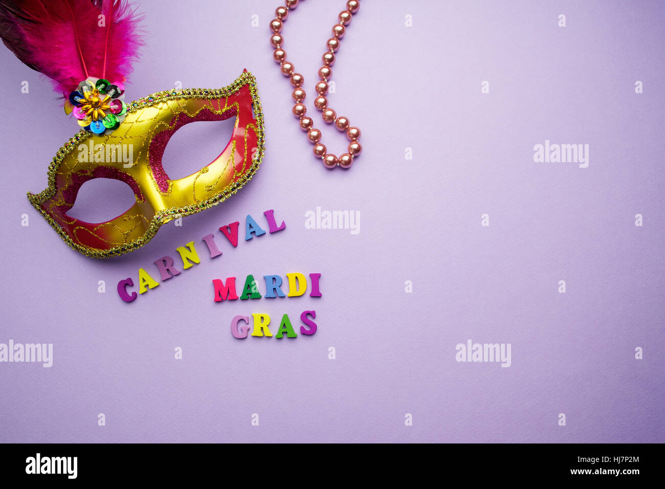 Colorful mardi gras or carnivale mask on a purple background. Venetian ...