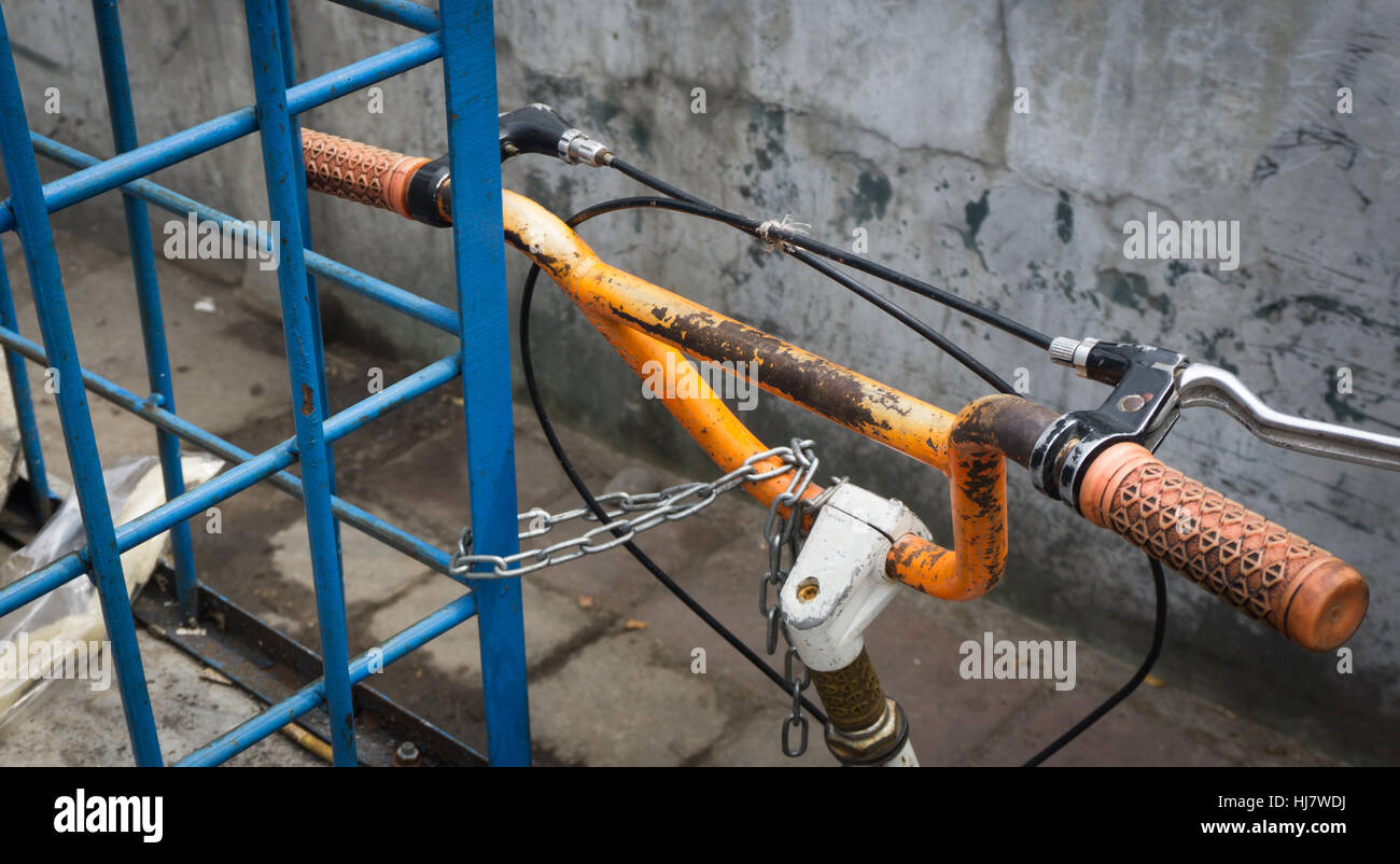 Orange handlebar of a parked bicycle locked by chain photo taken in ...