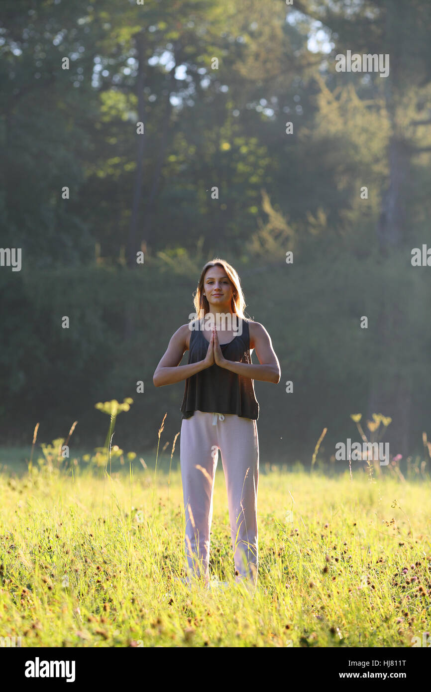 Girl standing in park with praying hands Stock Photo - Alamy