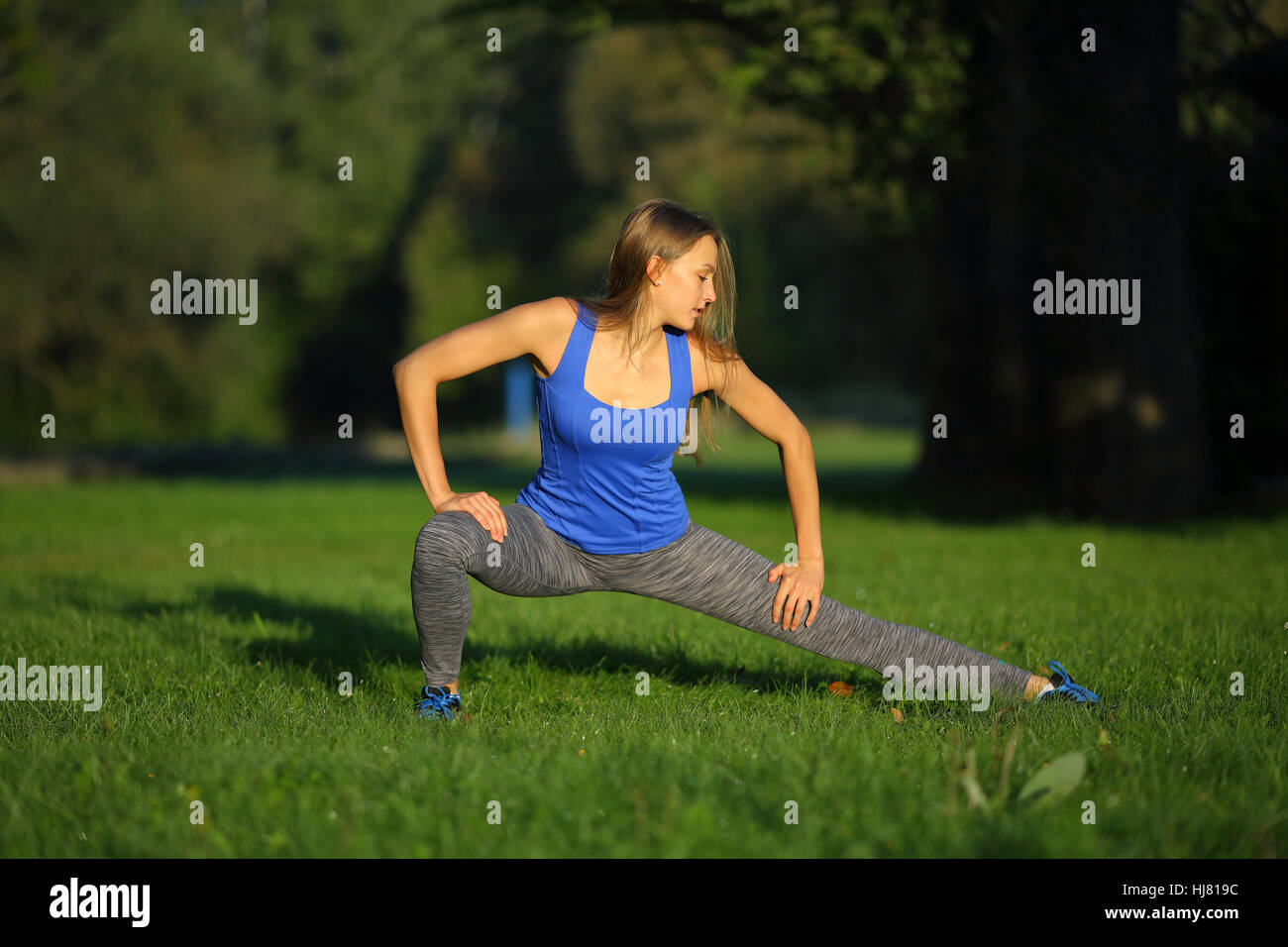 Beautiful young woman doing thrust in park Stock Photo - Alamy