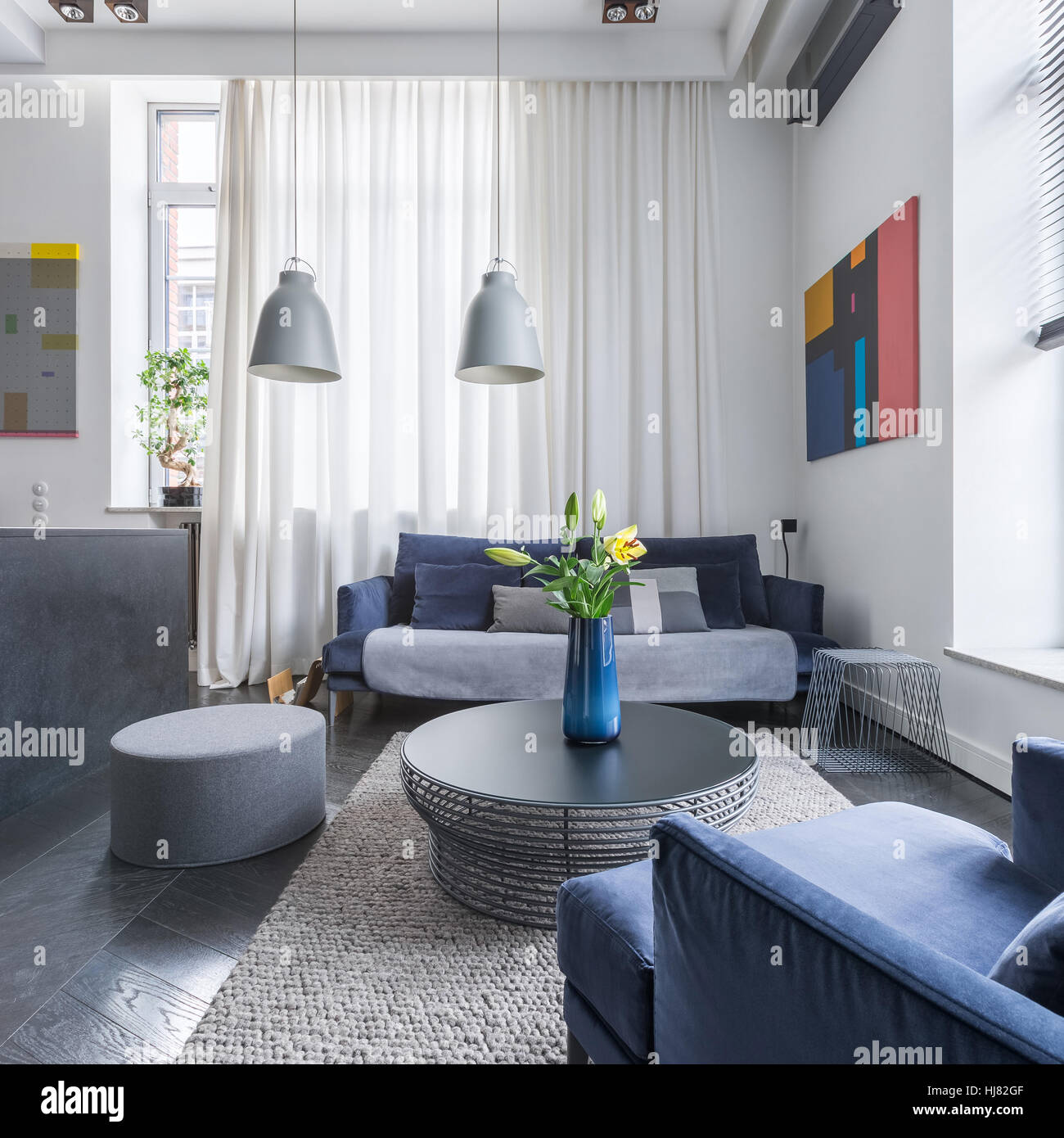 Spacious living room with upholstered blue sofa and armchair Stock ...