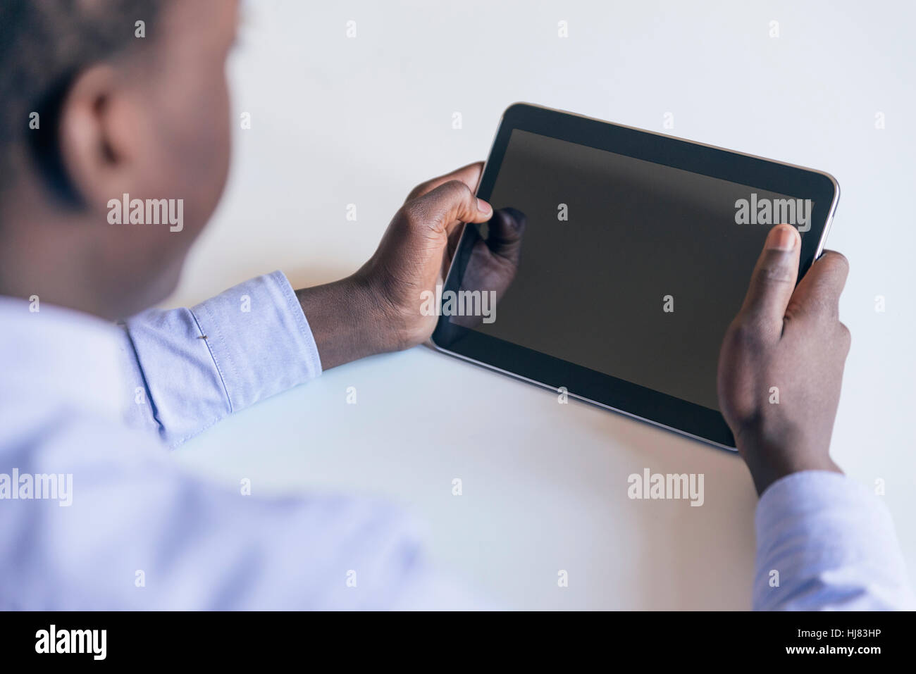Young African Businessman using his tablet at the office Stock Photo ...