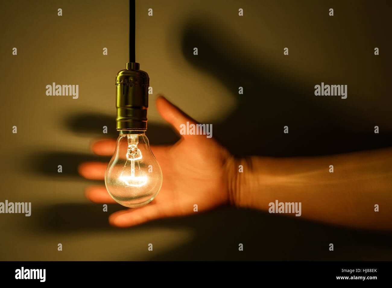 light bulb and hand with dark background Stock Photo - Alamy