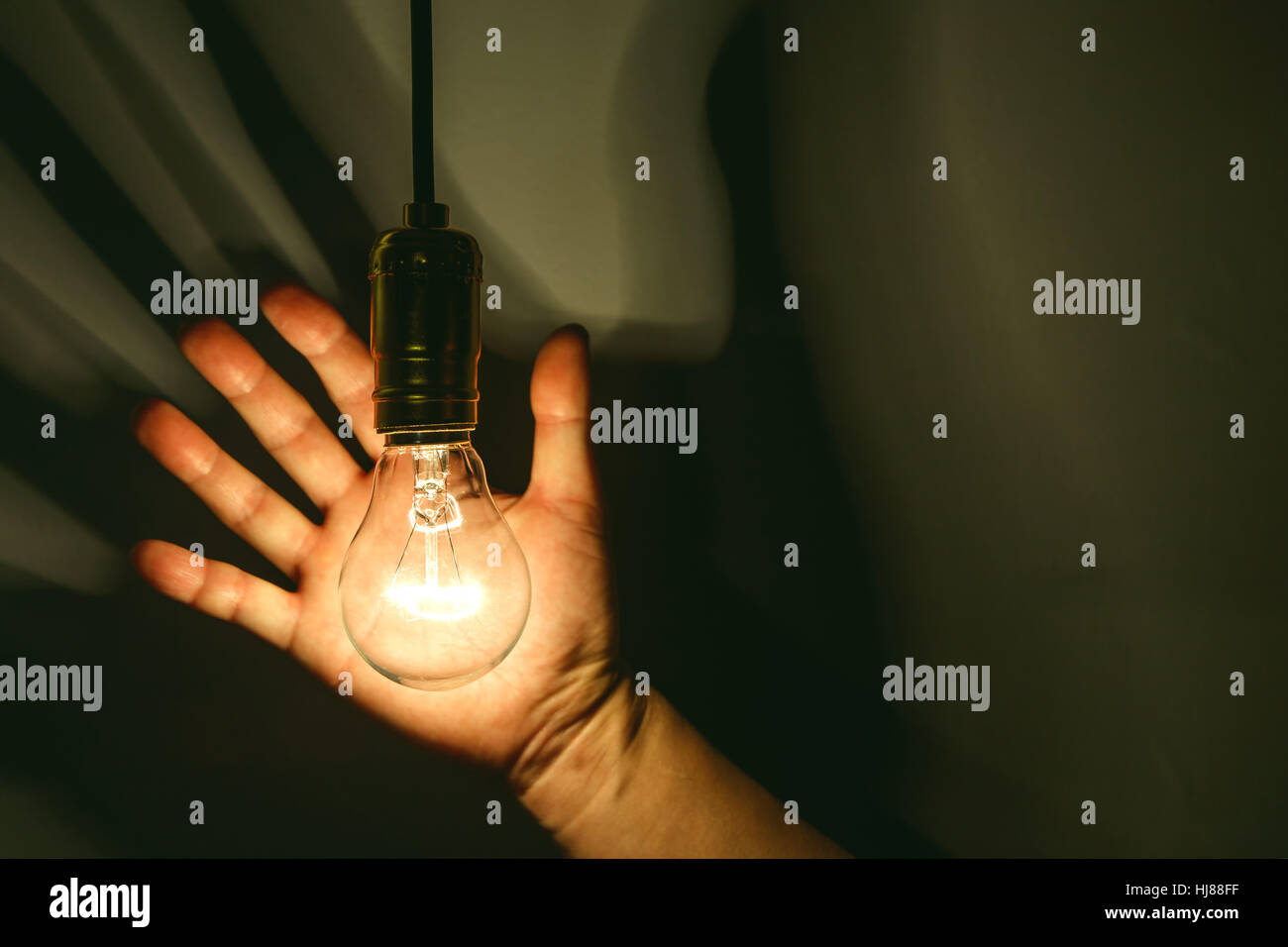 light bulb and hand with dark background Stock Photo - Alamy