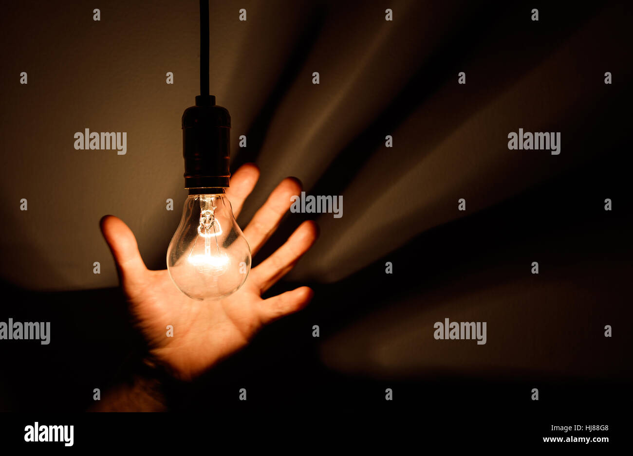 light bulb and hand with dark background Stock Photo - Alamy