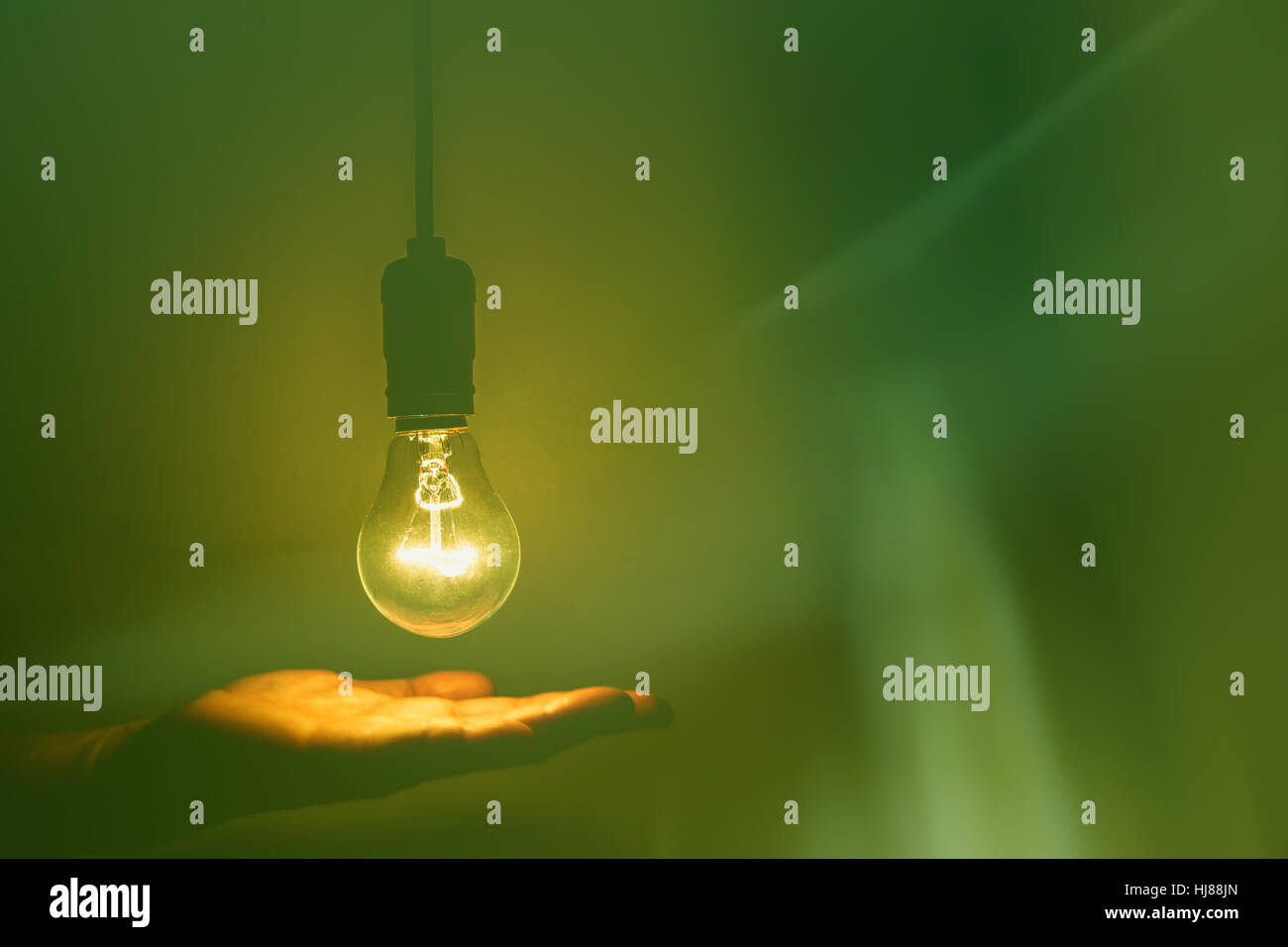 light bulb and hand with green background Stock Photo - Alamy