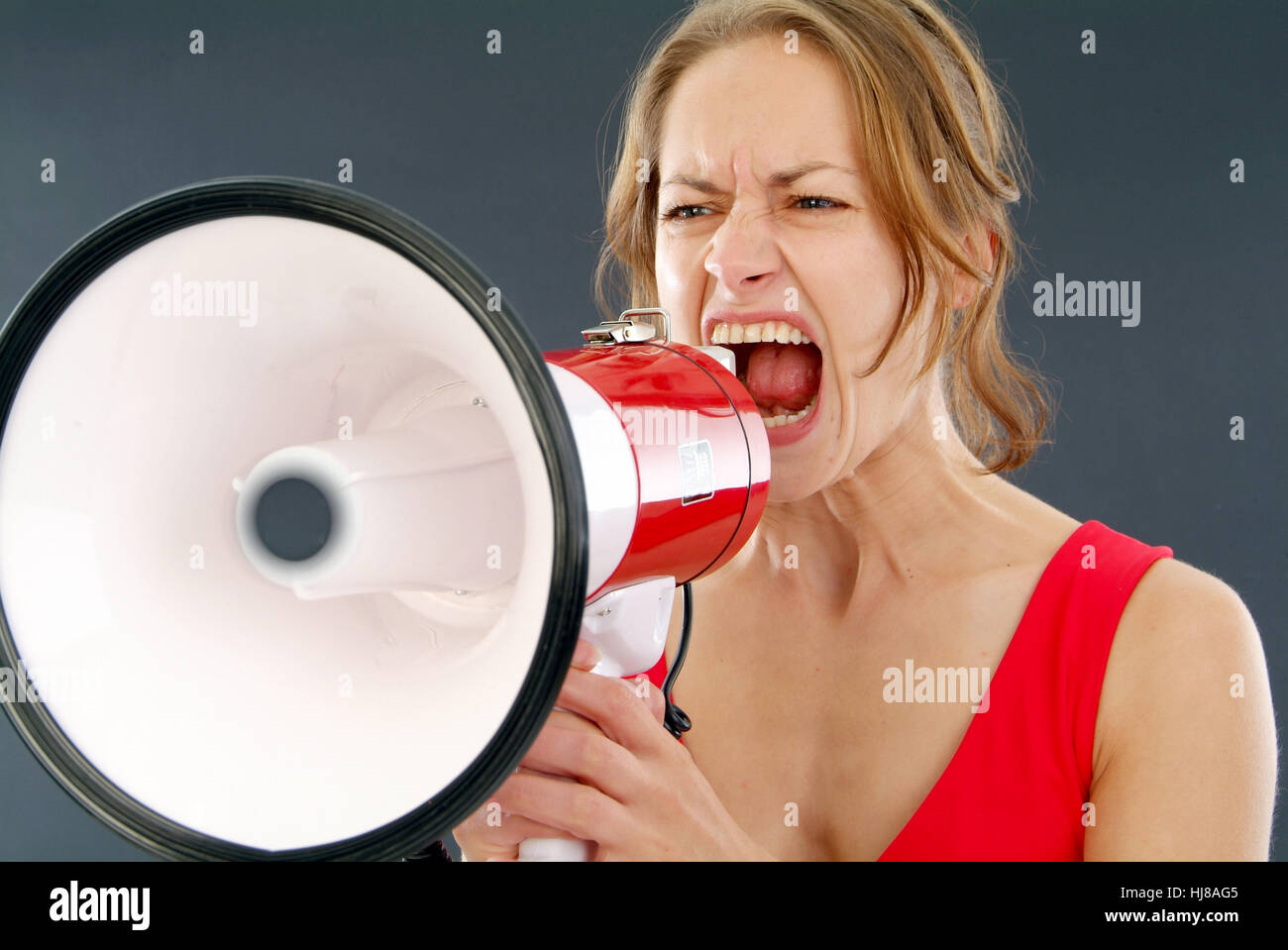Young woman screaming in a megaphone Stock Photo - Alamy