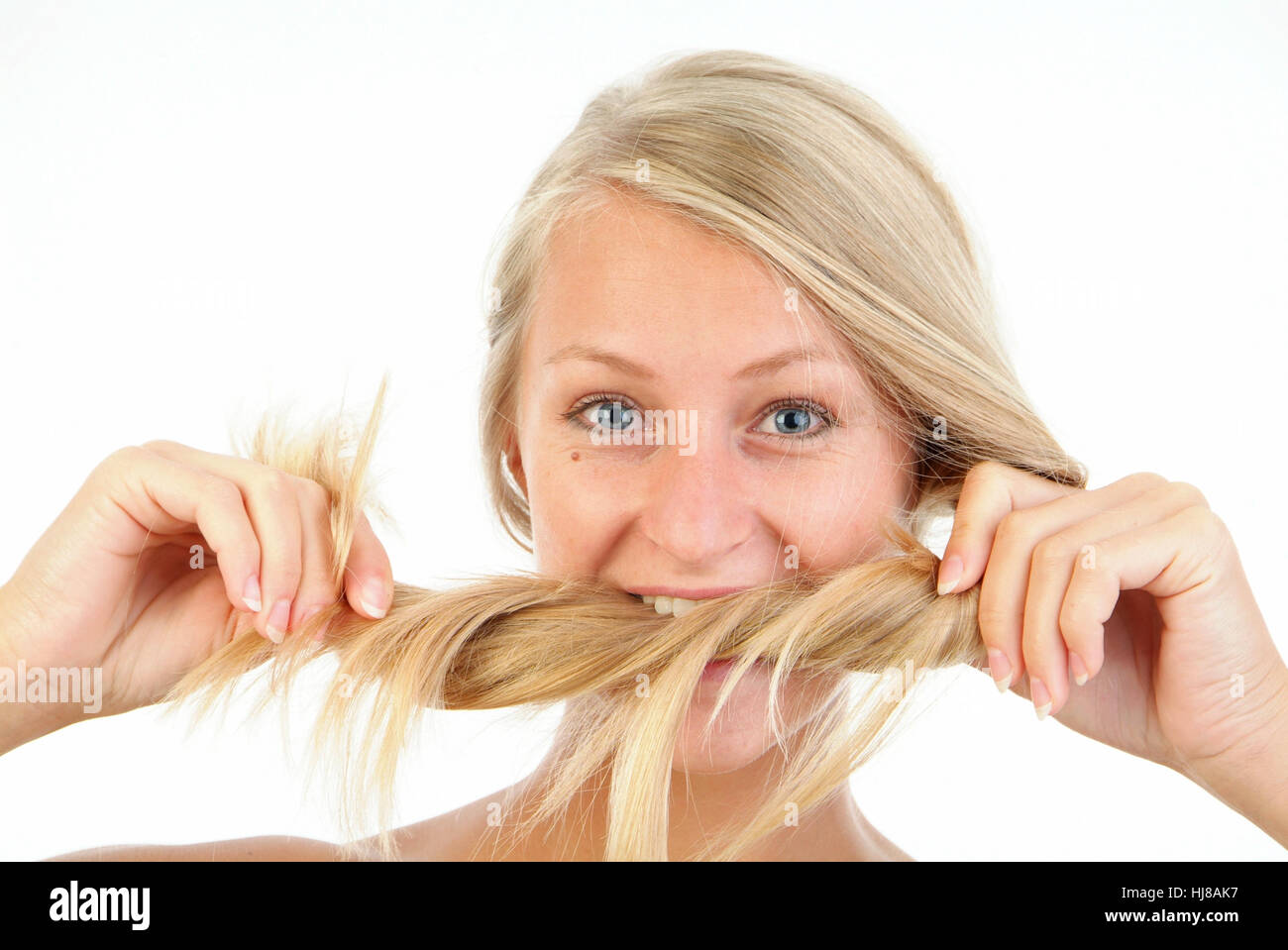 Young, blond woman biting in her hair Stock Photo - Alamy