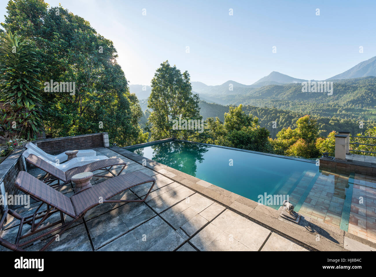Landscape, swimming pool with deck chairs, hills, Munduk, Bali ...
