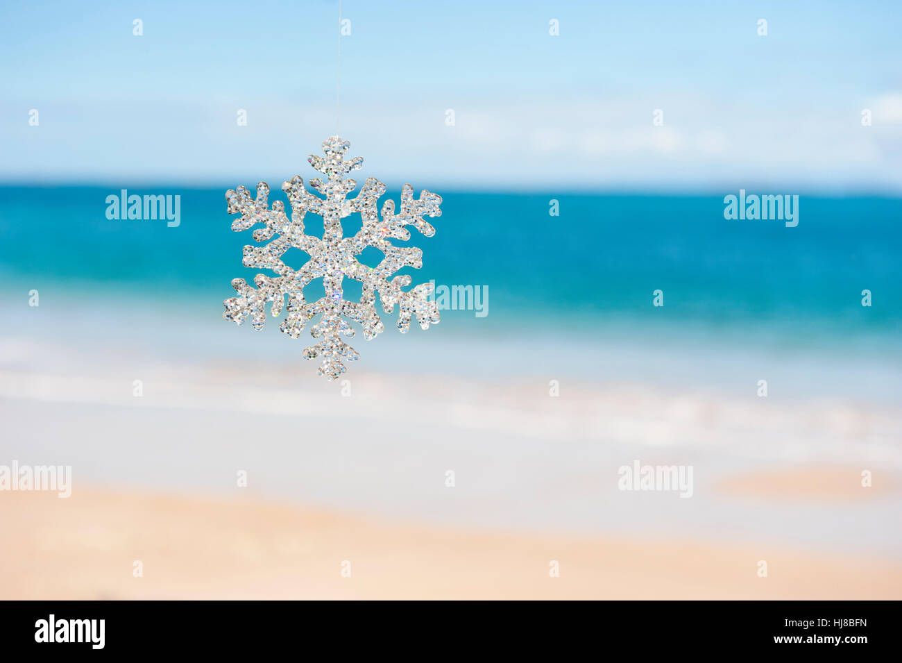 Snowflake ornament with a beach and ocean background Stock Photo - Alamy
