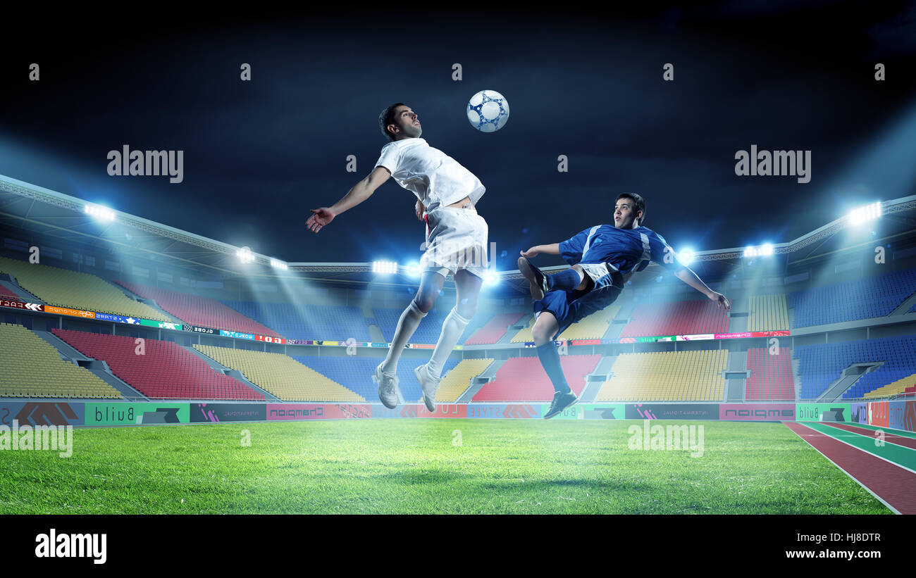 Two football player fighting for ball at stadium hi-res stock ...